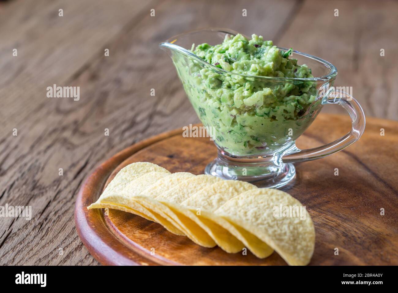 Guacamole with chips on the wooden board Stock Photo - Alamy