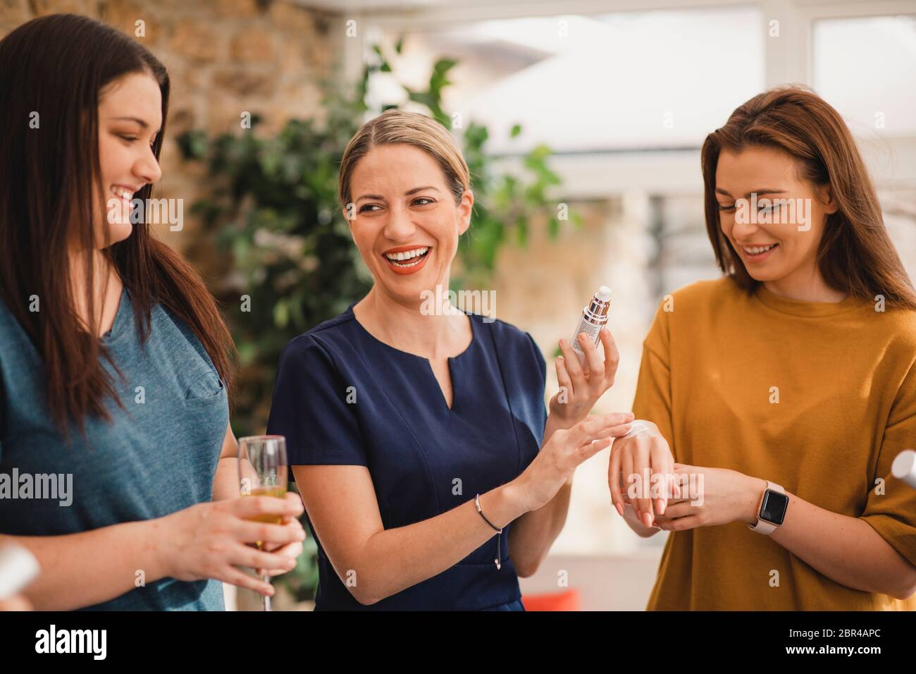 A beauty product sales representative showing customers products. She ...