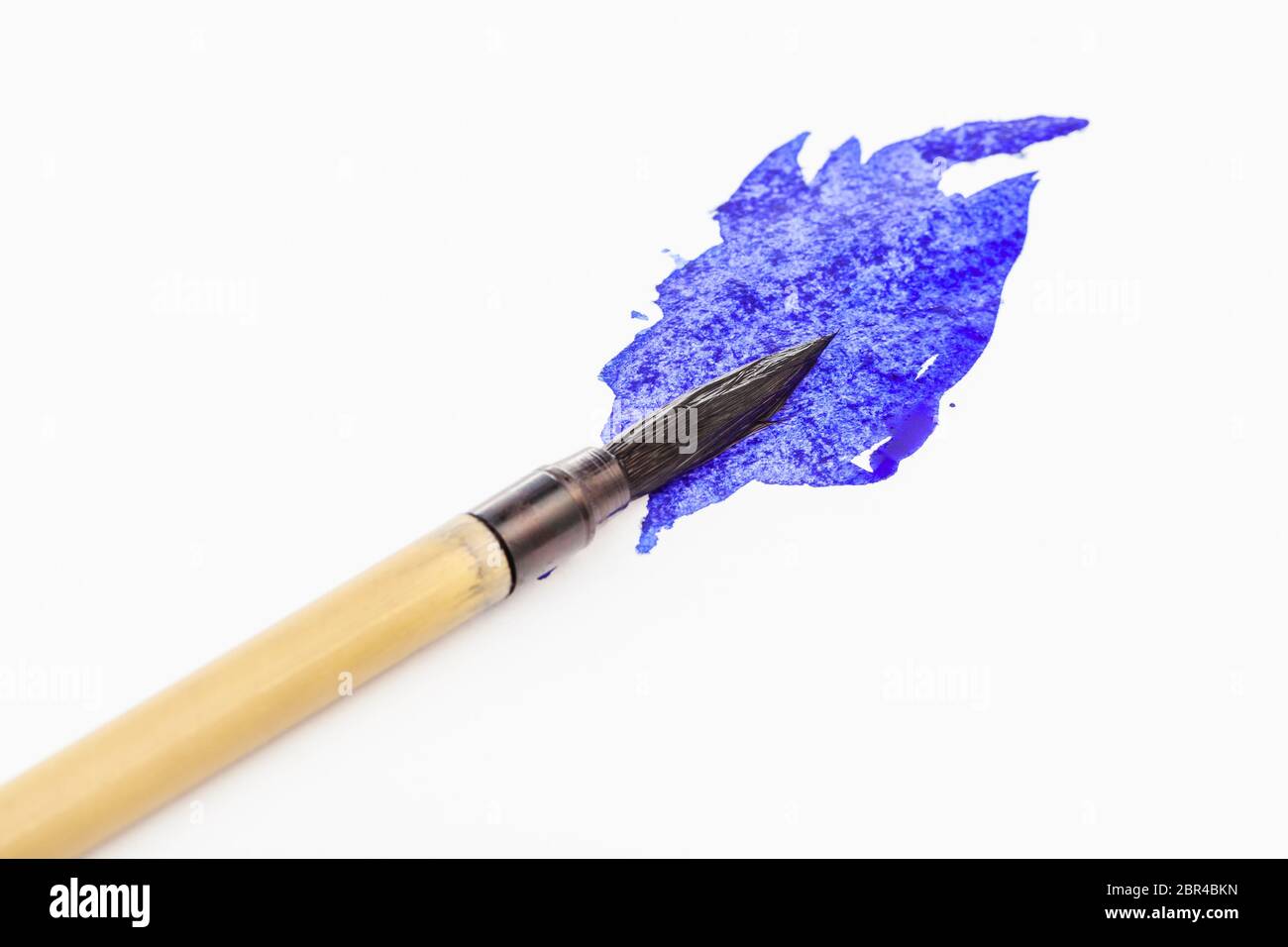 blue painted tip of paintbrush for sumi-e ( suibokuga) painting in blue ...
