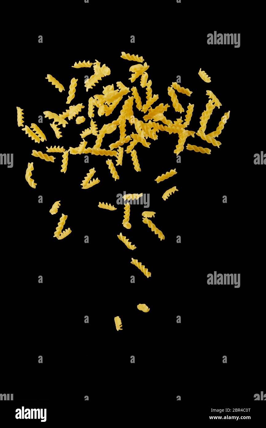 Italian flying raw pasta isolated on black background. macaroni fusilli ...