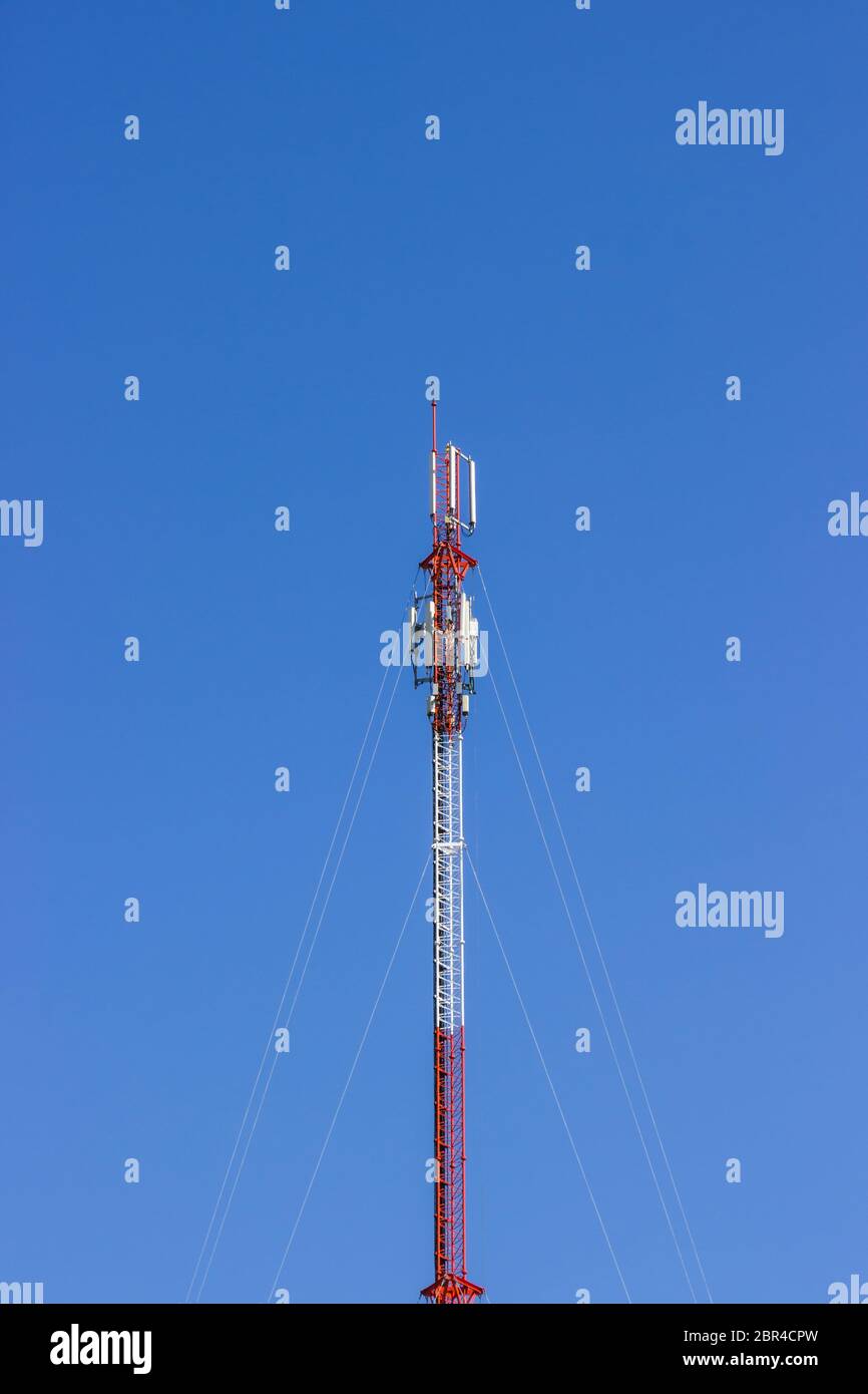 Red and white Telecommunication tower in a day of clear blue sky ...