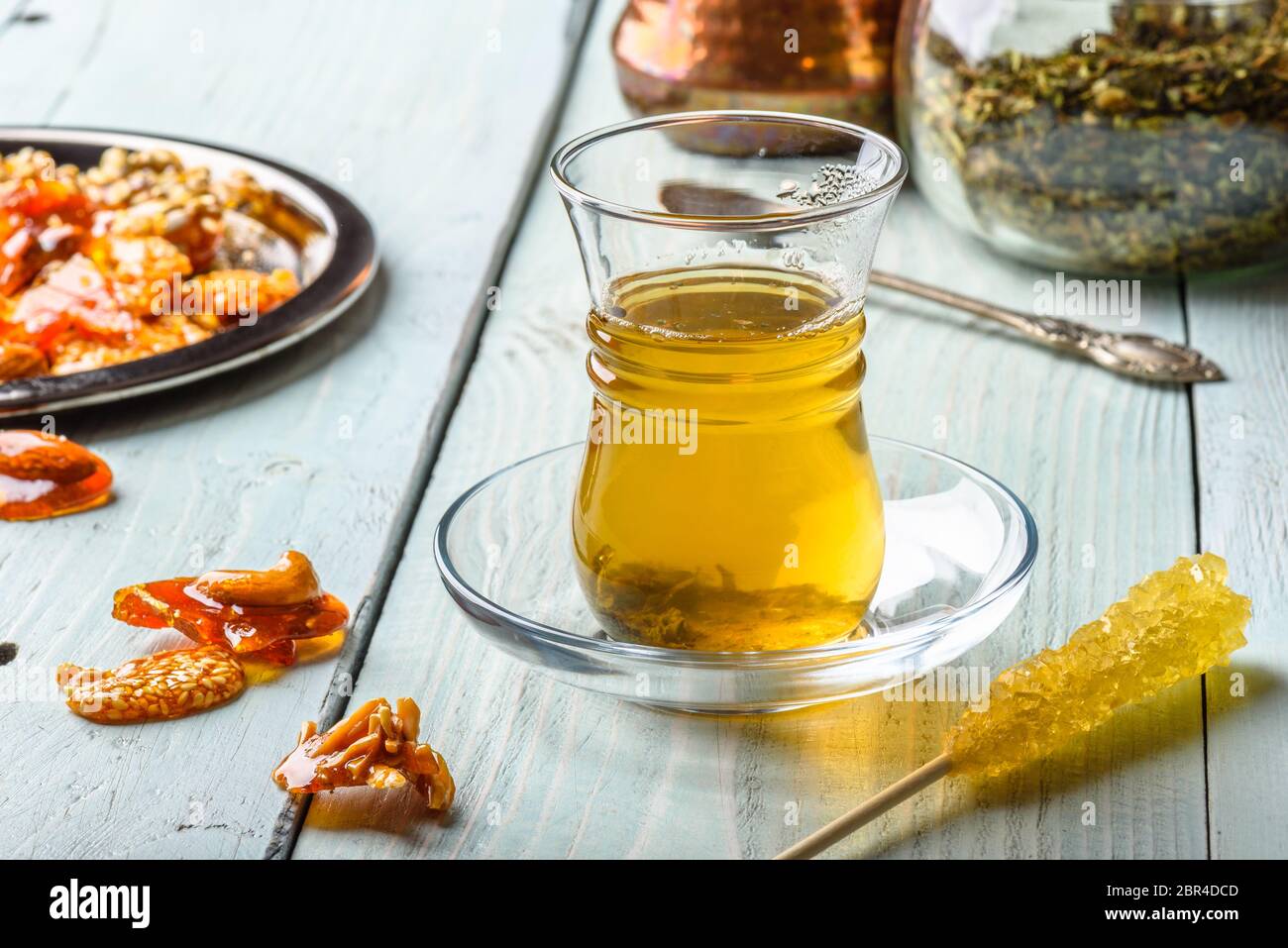 Herbal tea in armudu glass with arabic delights on metal plate over ...
