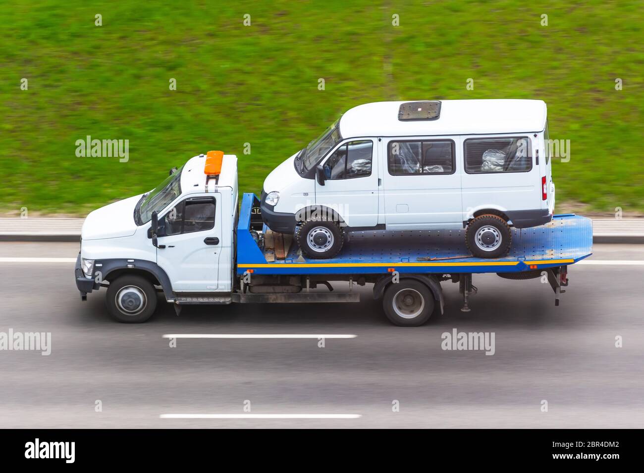 Carriage of a small minibus on the platform tow truck Stock Photo - Alamy