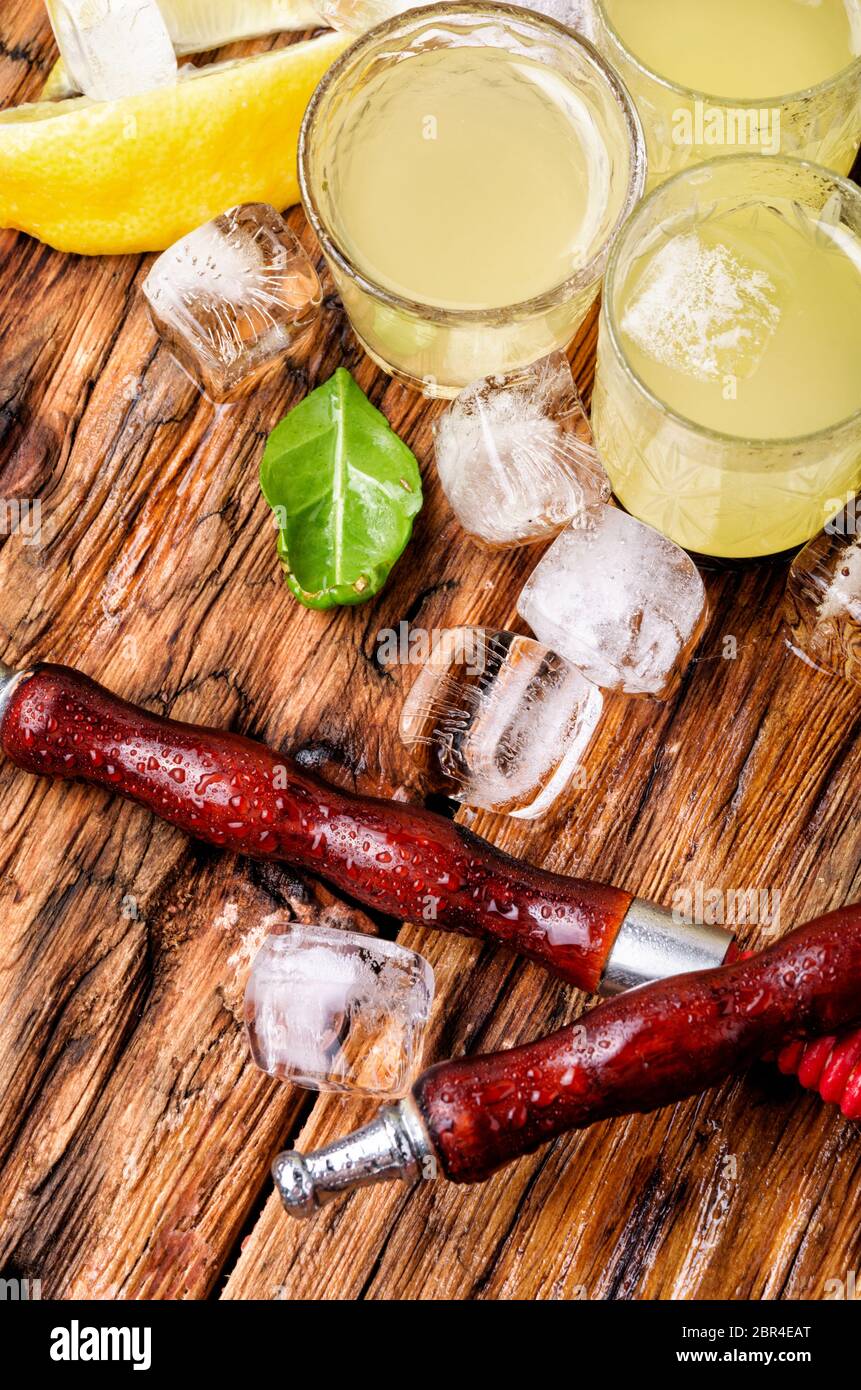 Smoking shisha and glasses with alcoholic limoncello.Hookah and alcohol ...