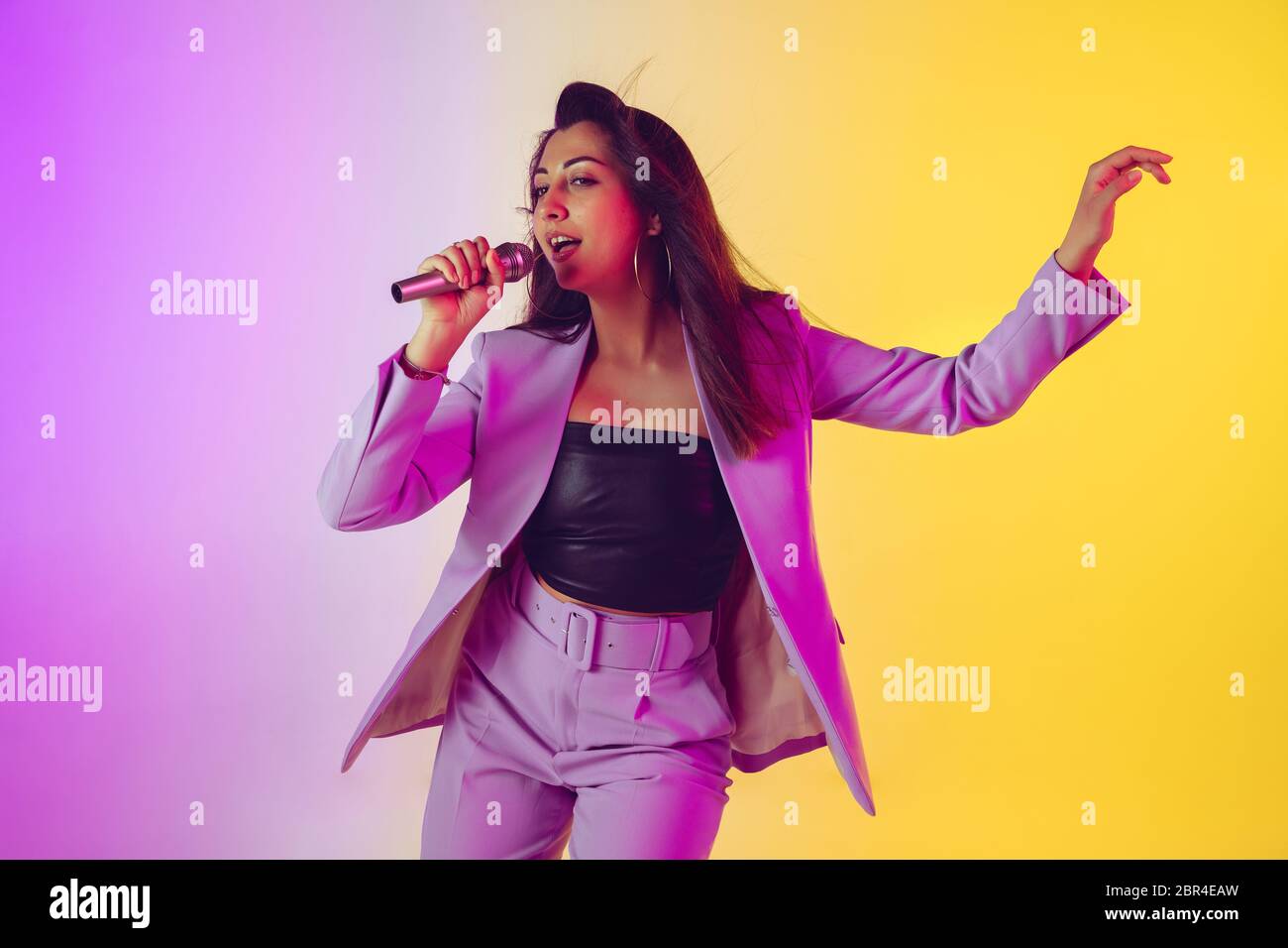 Caucasian female singer portrait isolated on gradient studio background ...