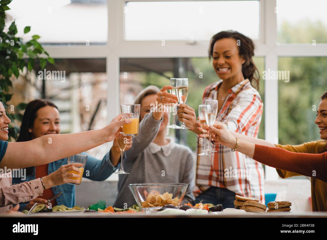 Small group of female friends preparing a healthy lunch inside of a ...