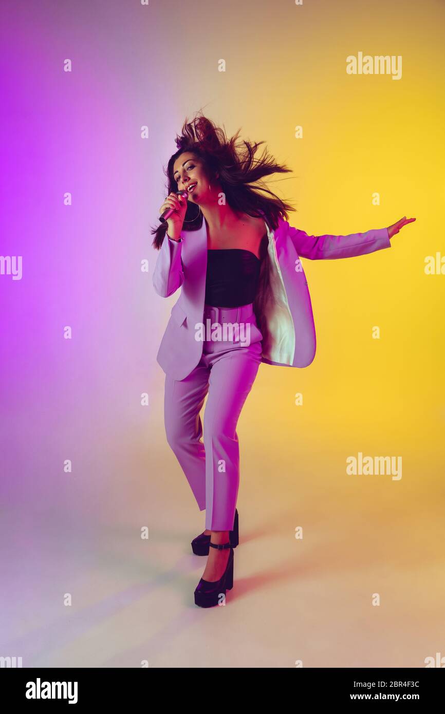 Caucasian female singer portrait isolated on gradient studio background ...