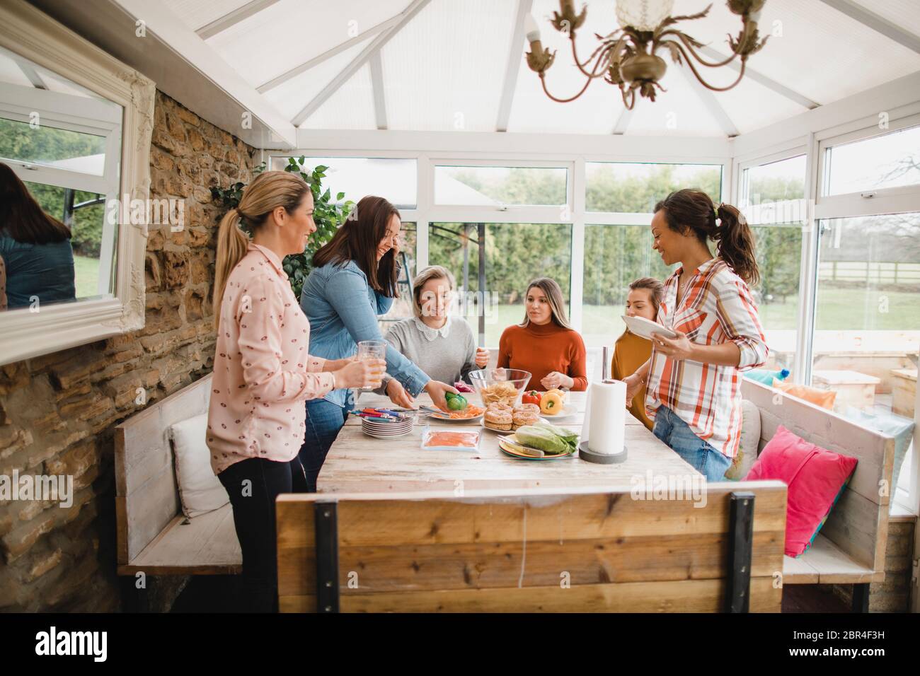 Small group of female friends preparing a healthy lunch inside of a ...