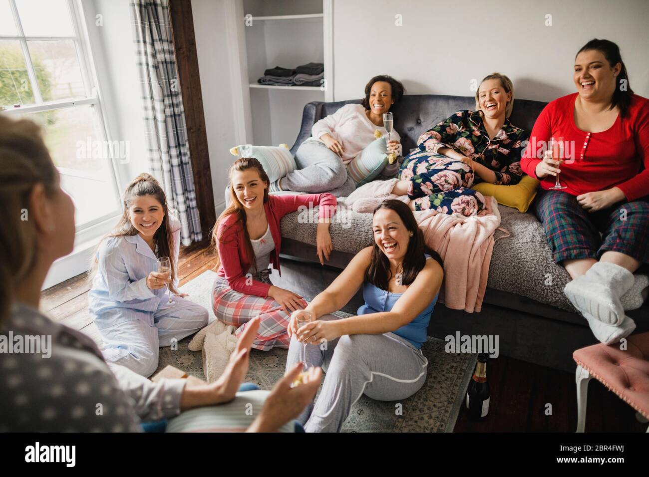 Small group of female friends relaxing and talking while enjoying a ...