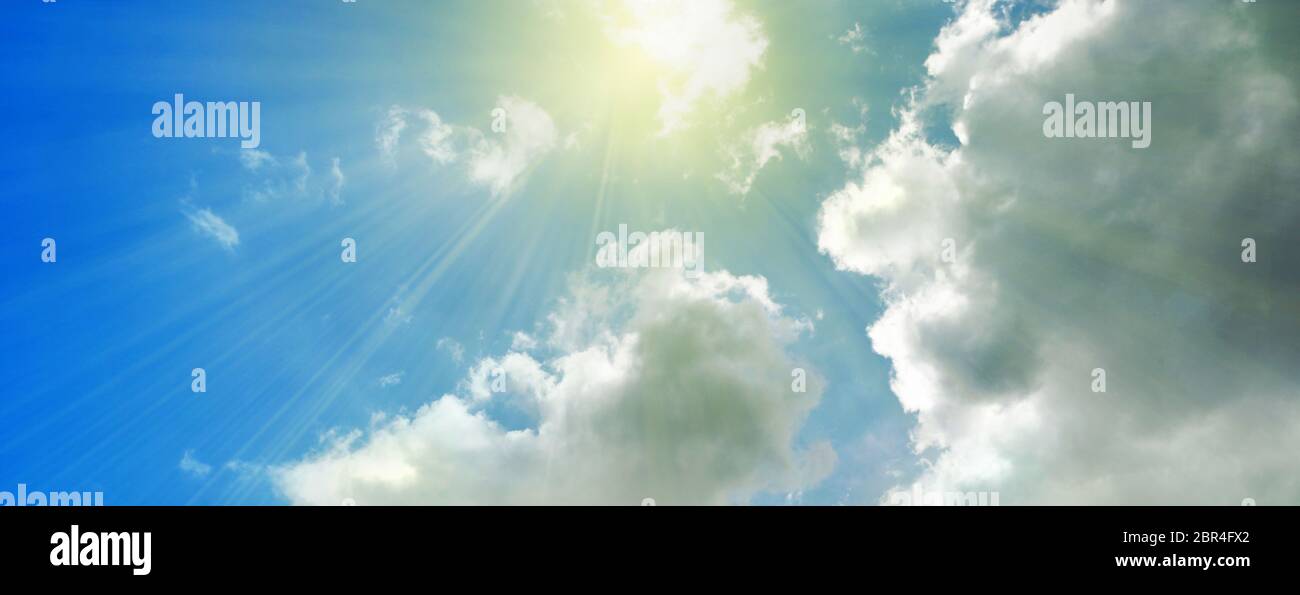 Rays of streaming sunlight on cloudy blue sky background. Summer ...