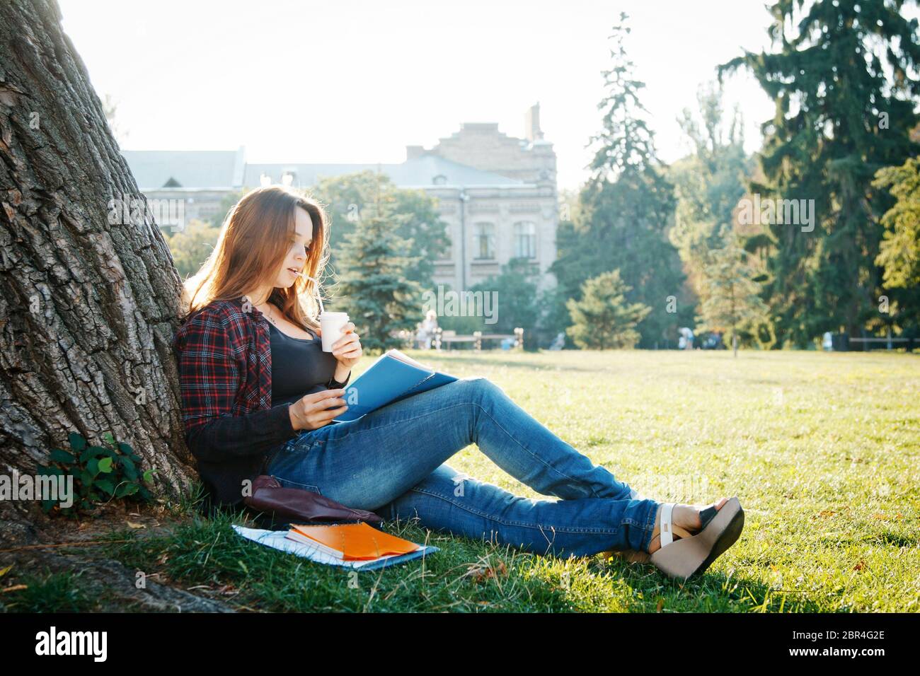 girl student near a tree is waiting for the start of the lesson and ...