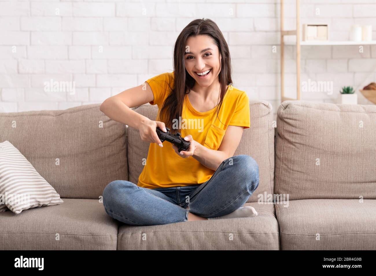 Home entertainment. Happy lady with joystick playing online computer ...