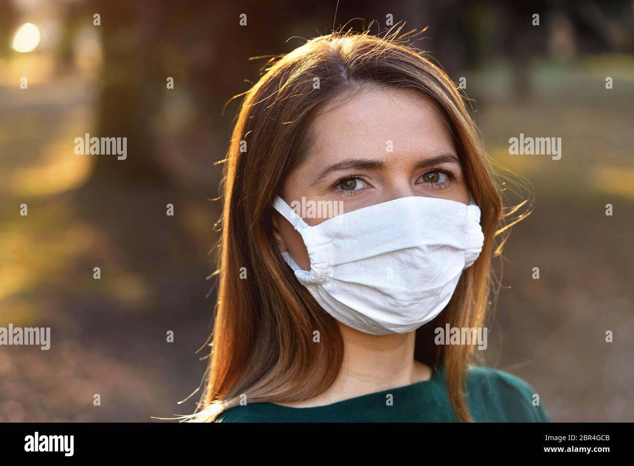 Young woman wearing white cotton virus mouth nose mask, nice bokeh ...