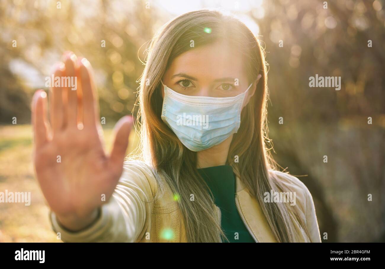 Young woman wearing blue disposable single use virus mouth nose mask ...