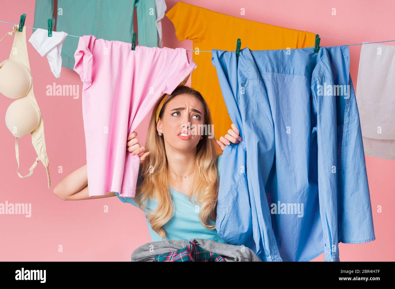 Tired of washing concept. Sad housewife push apart washed clothes on ...