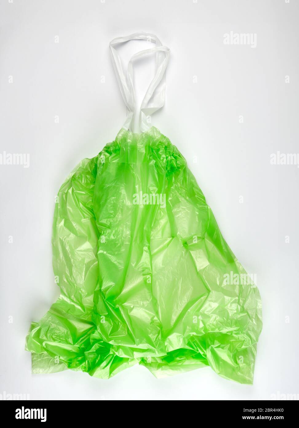 empty transparent green plastic garbage bag with handles on a white ...