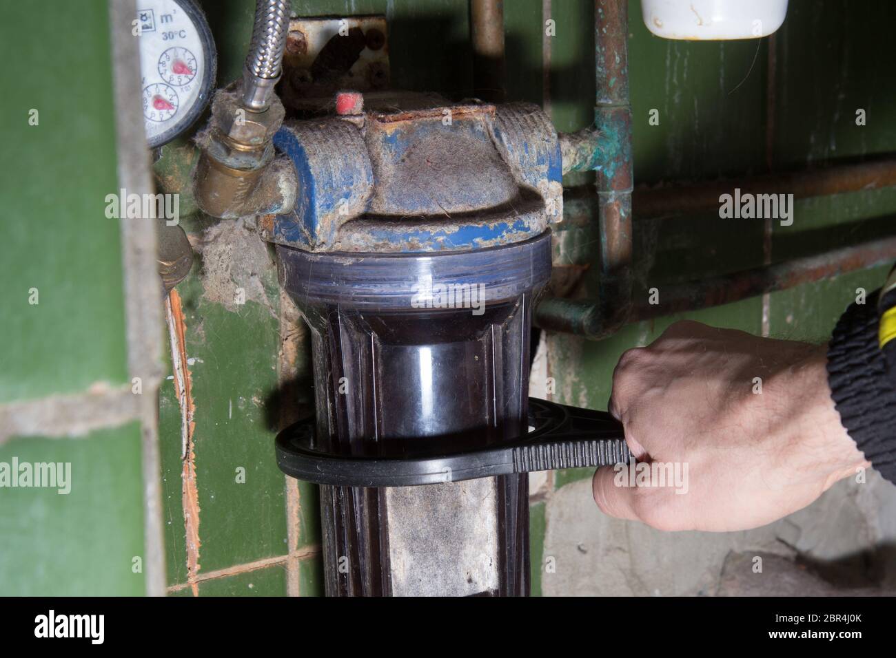 Men's hand trying replace old water filter Stock Photo - Alamy