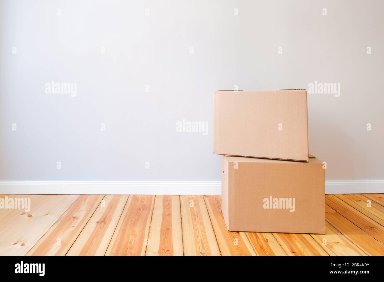 two cardboard boxes in empty room with wall background and copy space ...