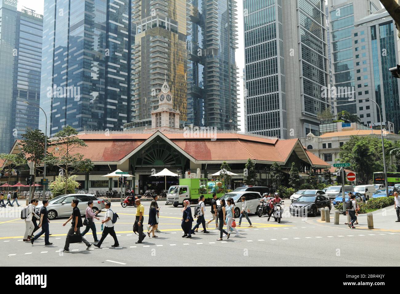 Pedestrians crossing a busy street in the Singapore central business ...