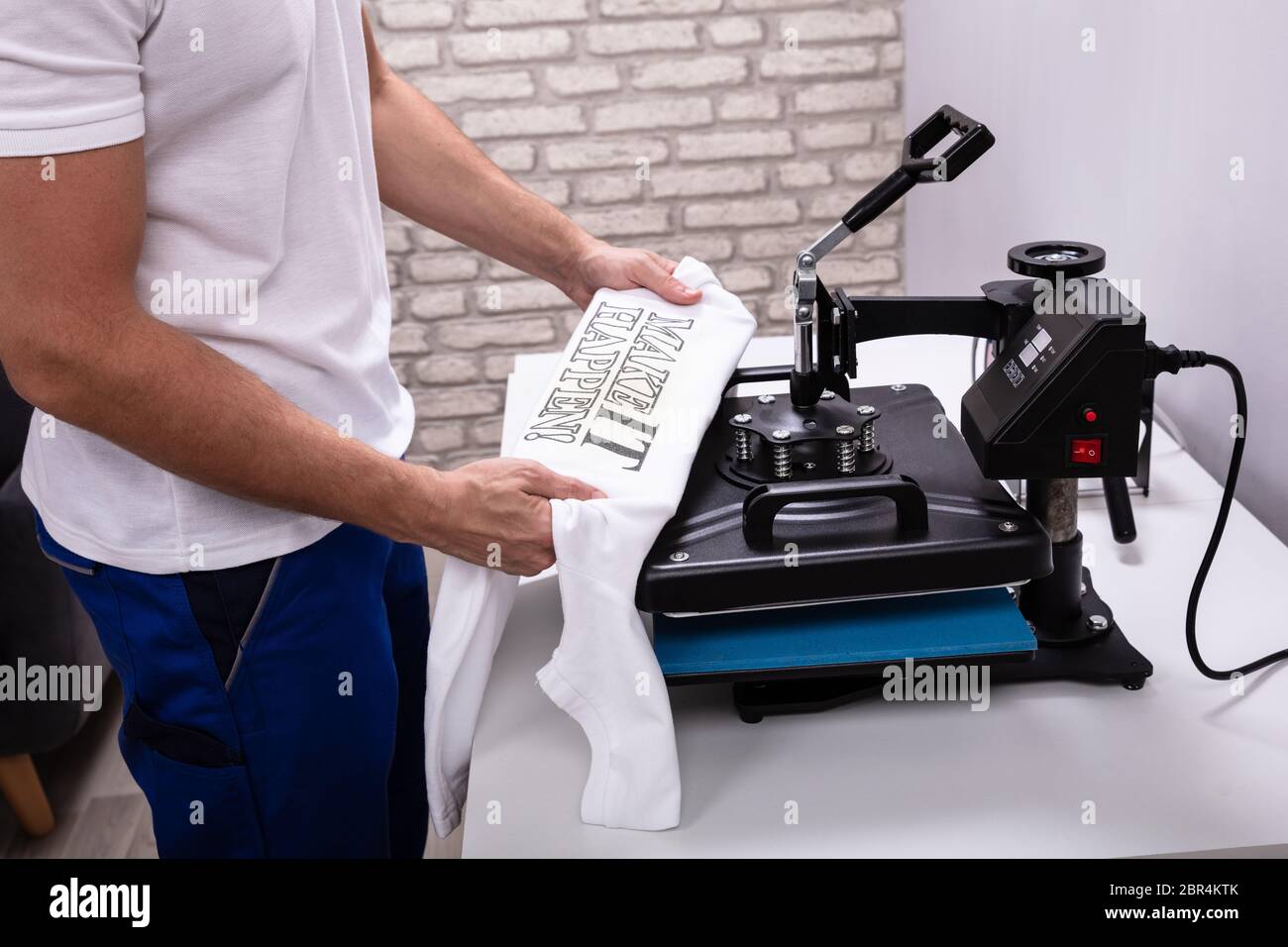 Man printing on t shirt in workshop Stock Photo - Alamy