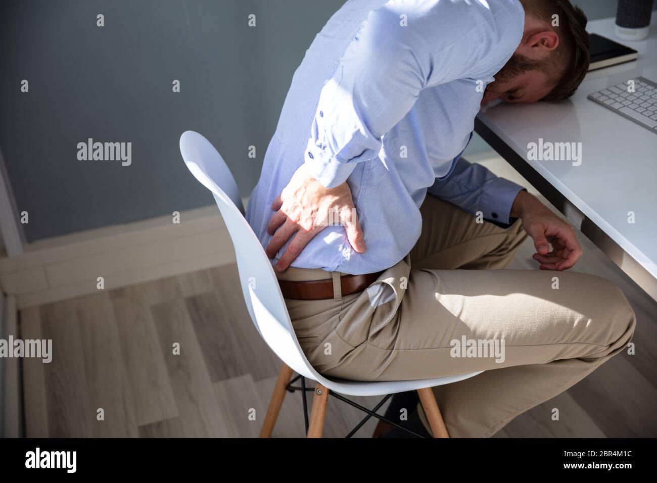 Businessman Suffering From Backache At Computer Desk Stock Photo - Alamy