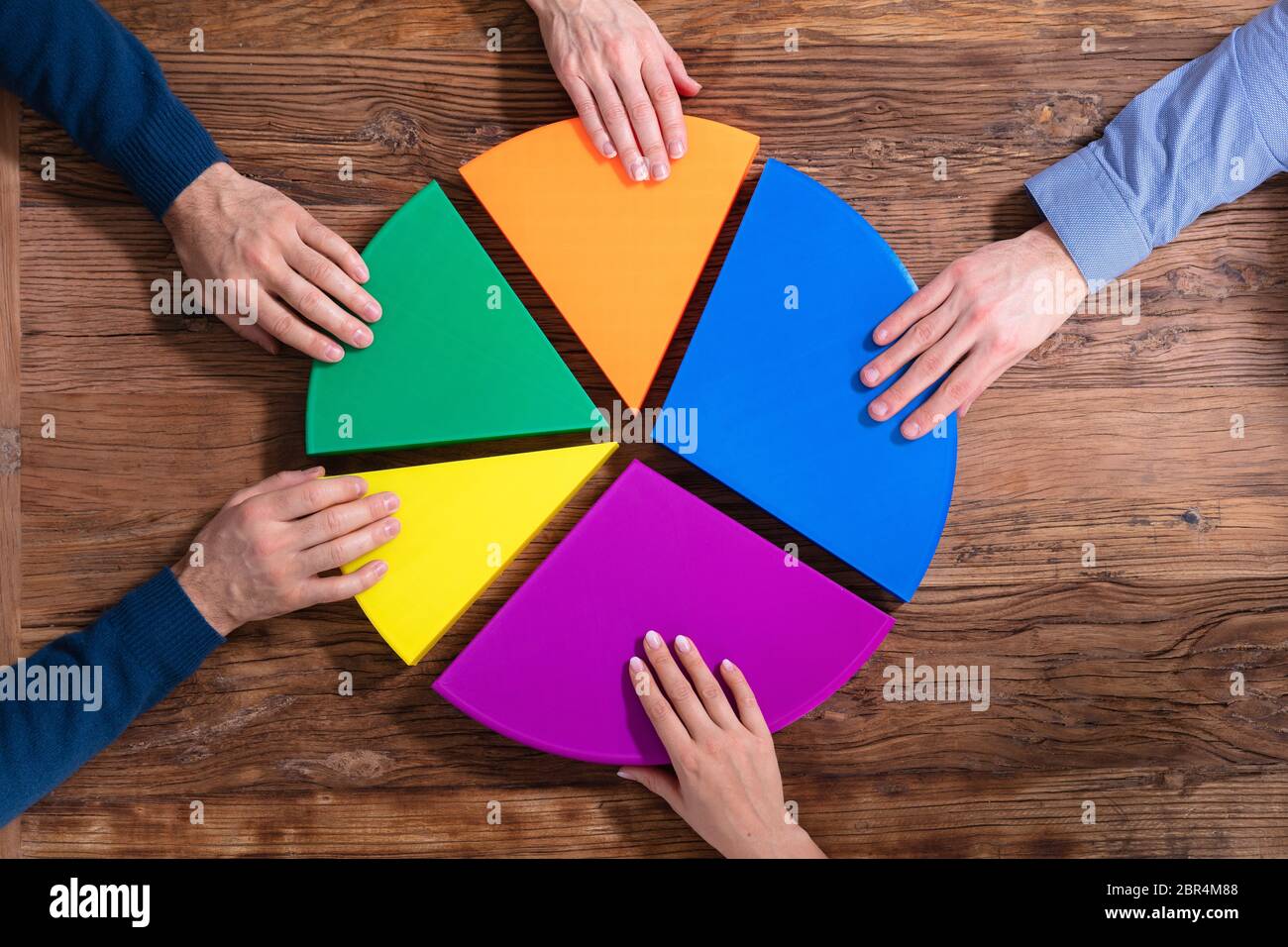 An Overhead View Of Businesspeople Connecting Pieces Of Multicolored ...