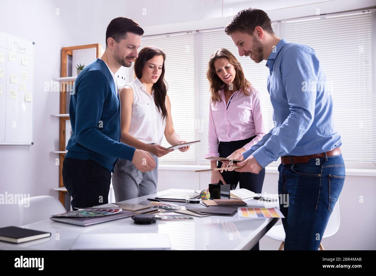 Group Of Young Businesspeople Working Together Choosing Color Palette ...