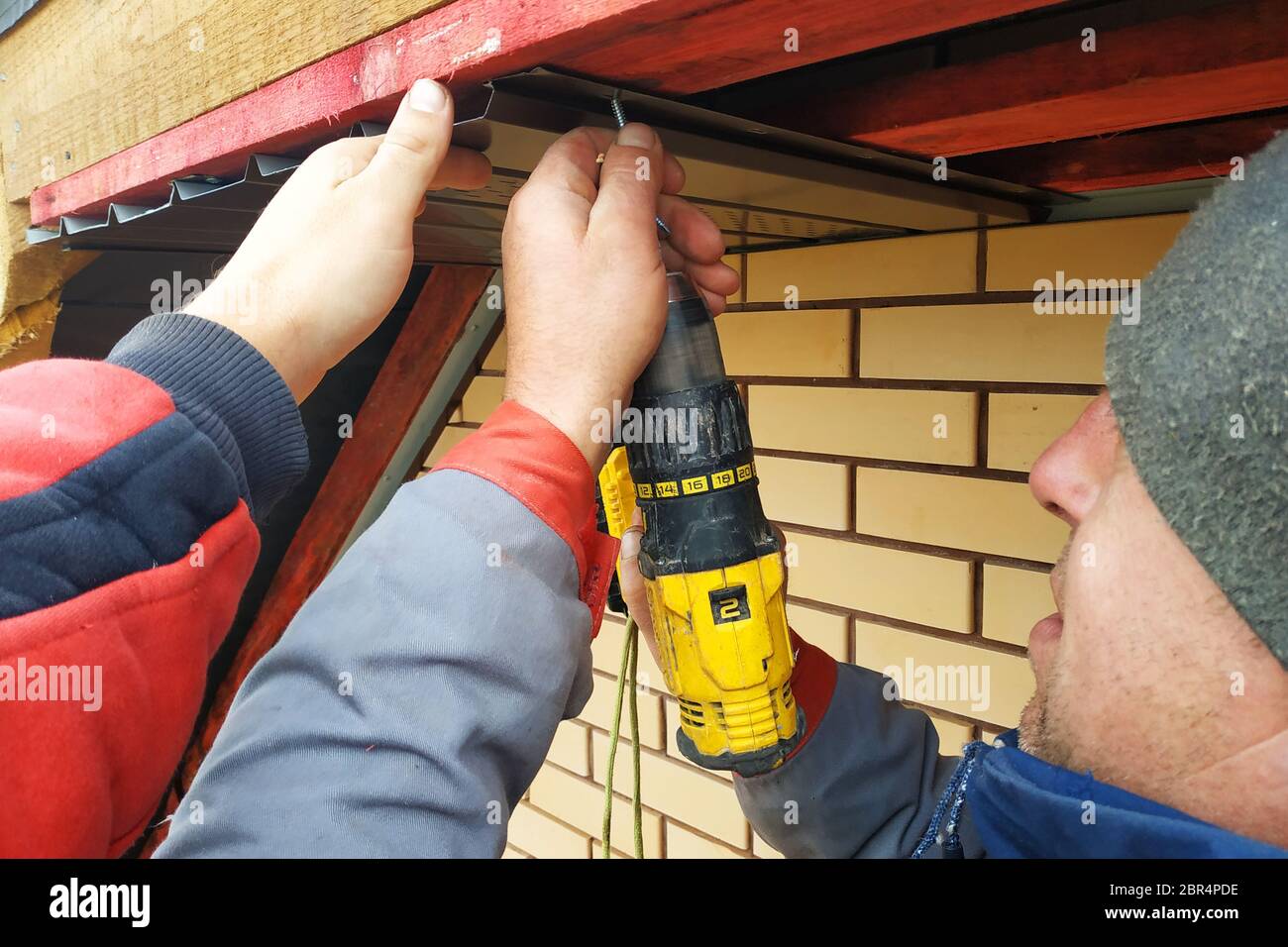 Workers install eaves under the roof of the house.2020 Stock Photo - Alamy