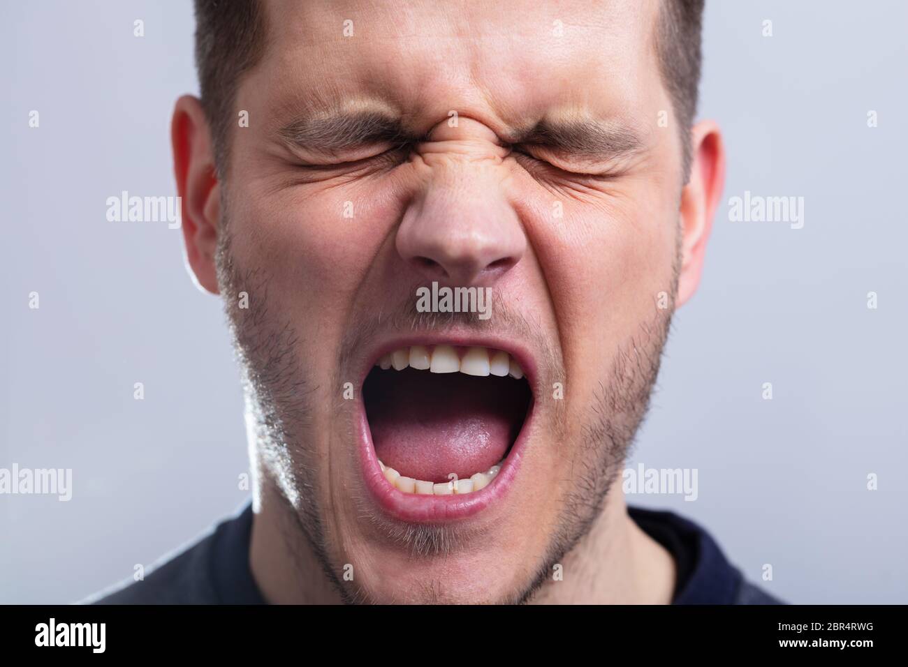 Portrait Of A Young Man Screaming Against White Background Stock Photo ...