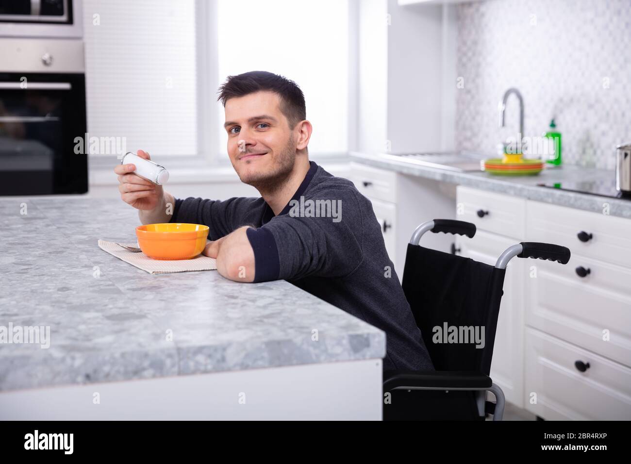 Smiling Disabled Young Man Sitting On Wheelchair Drinking Soup In The ...