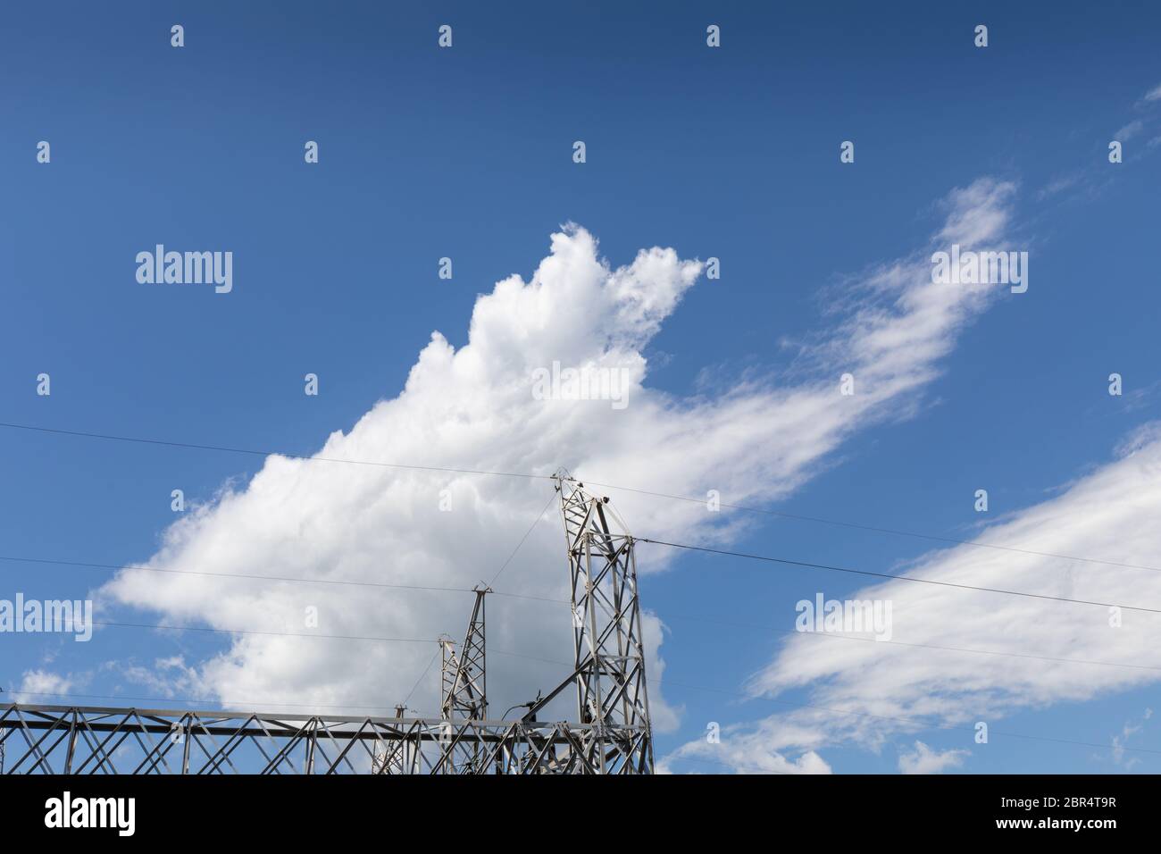 Steel metal electrical power trusses against a beautiful blue sky with ...