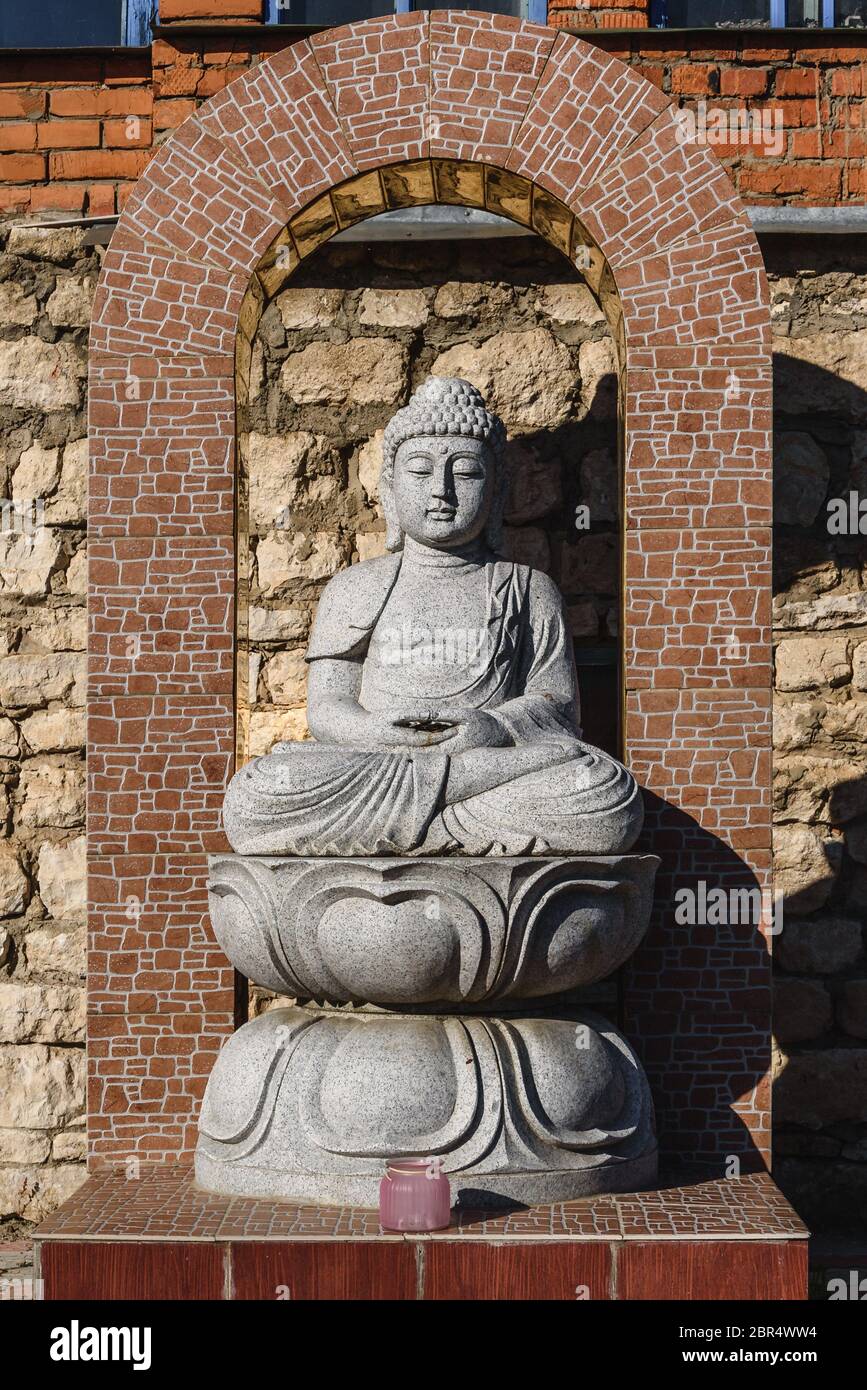 White stone statue of a Buddha on masonry background Stock Photo - Alamy