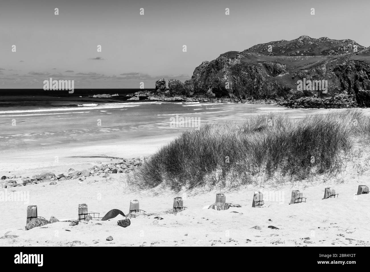 A lonely bay with deserted sandy beach by the sea in black and white ...