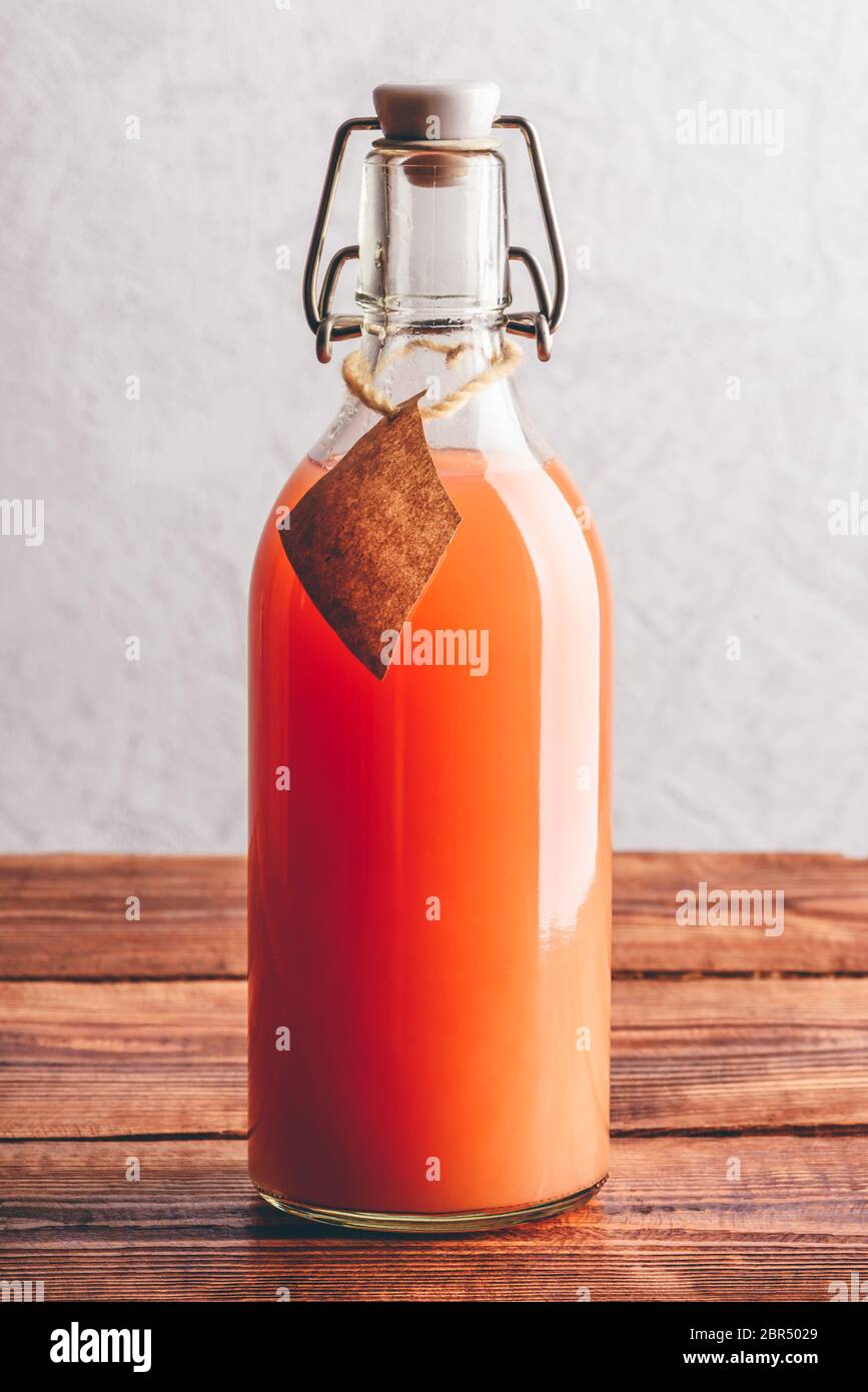 Bottle of grapefruit juice on wooden surface Stock Photo - Alamy