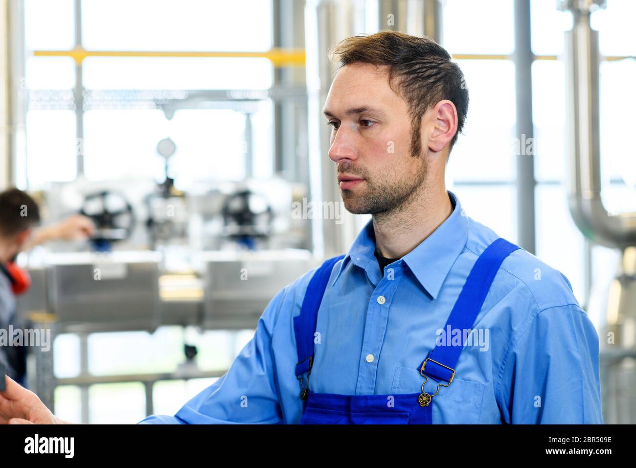 worker in blue work clothes in industrial plant Stock Photo - Alamy