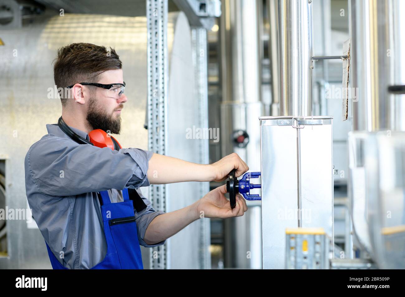 worker in blue work clothes in industrial plant Stock Photo - Alamy