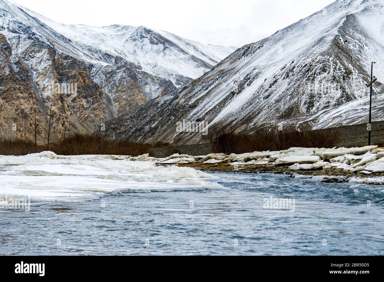 Frozen Indus river flowing through the snow covered mountains of Ladakh ...