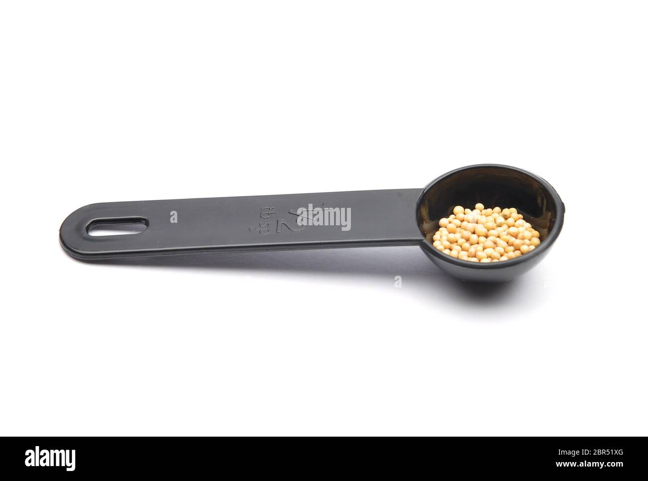 Mustard seeds in measuring spoon on white background Stock Photo - Alamy