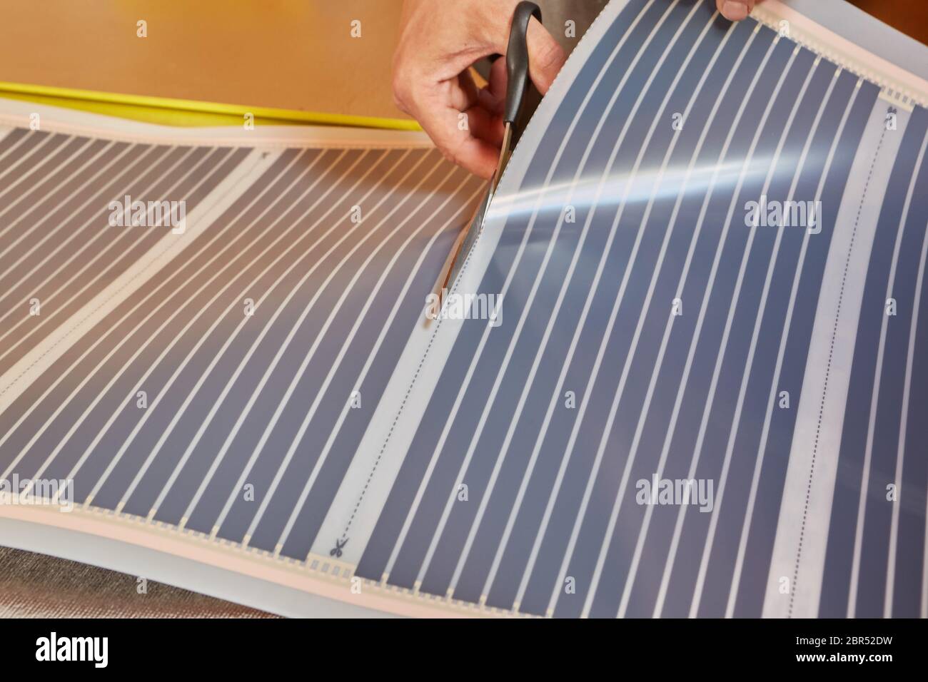 Installation infrared carbon heating film for floor. Male hand with ...