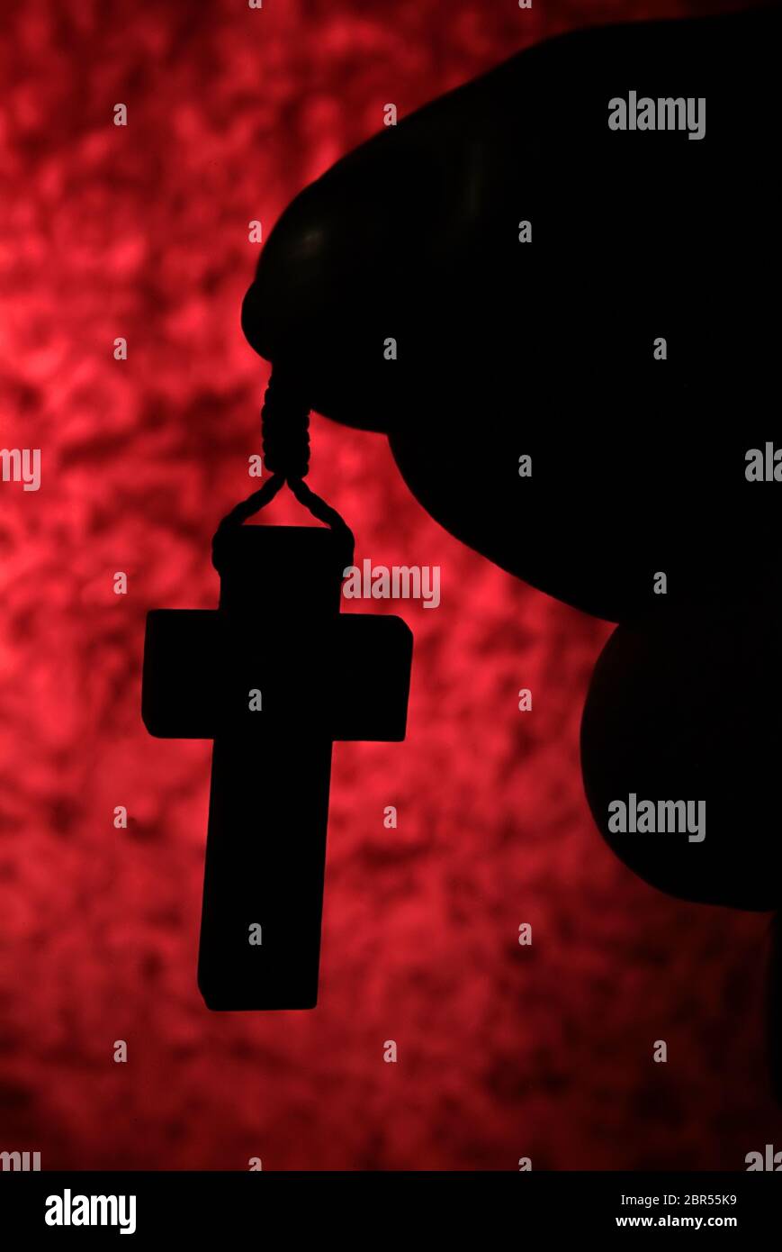 Silhouette of human praying to the GOD while holding a crucifix symbol ...
