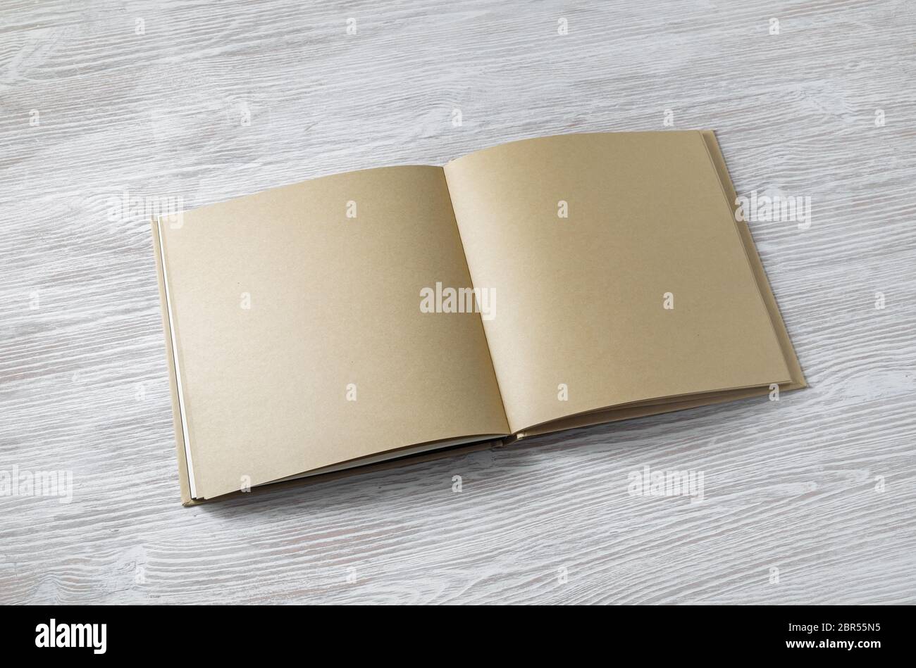 Open book with blank craft paper pages on light wooden background Stock ...