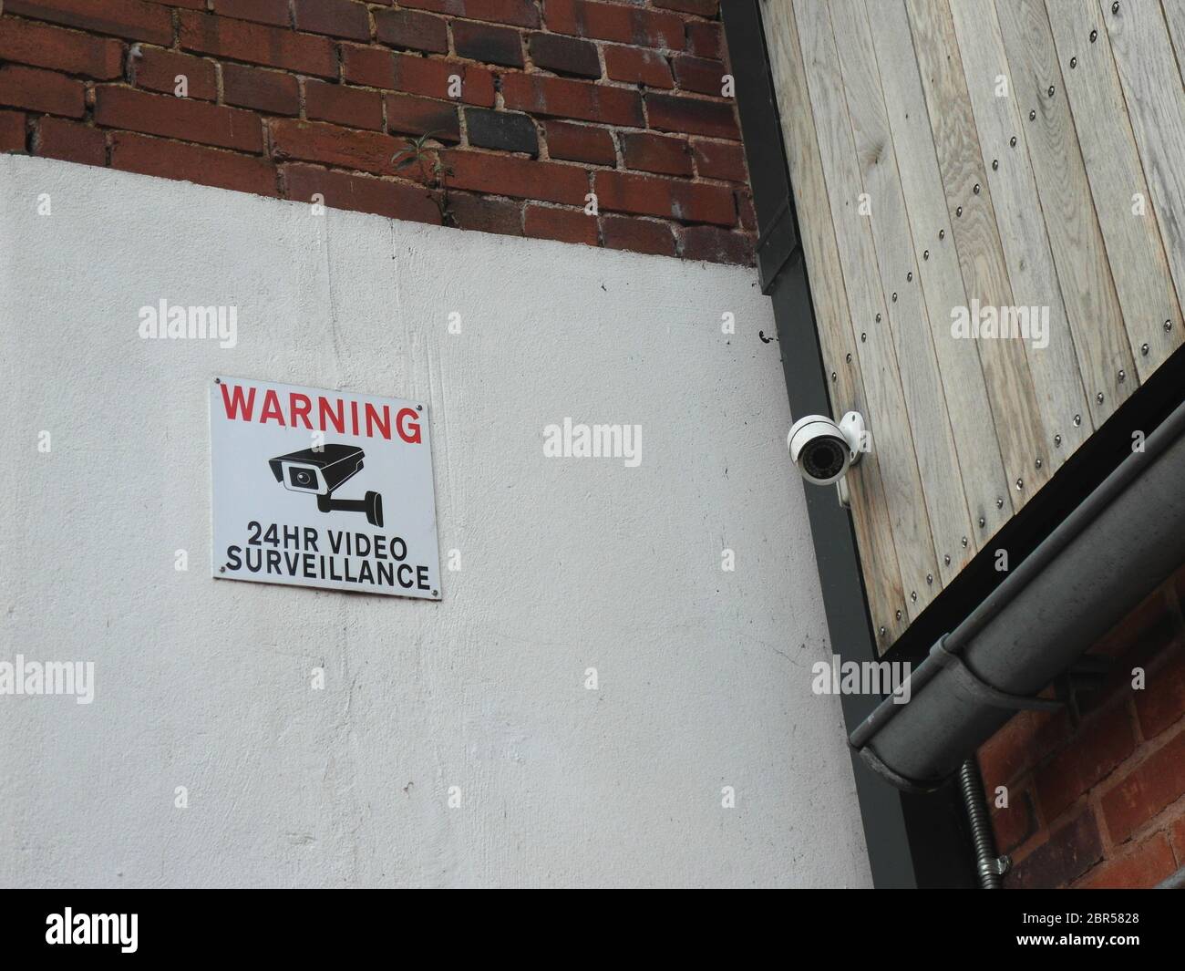 CCTV security camera and surveillance warning sign on building exterior ...