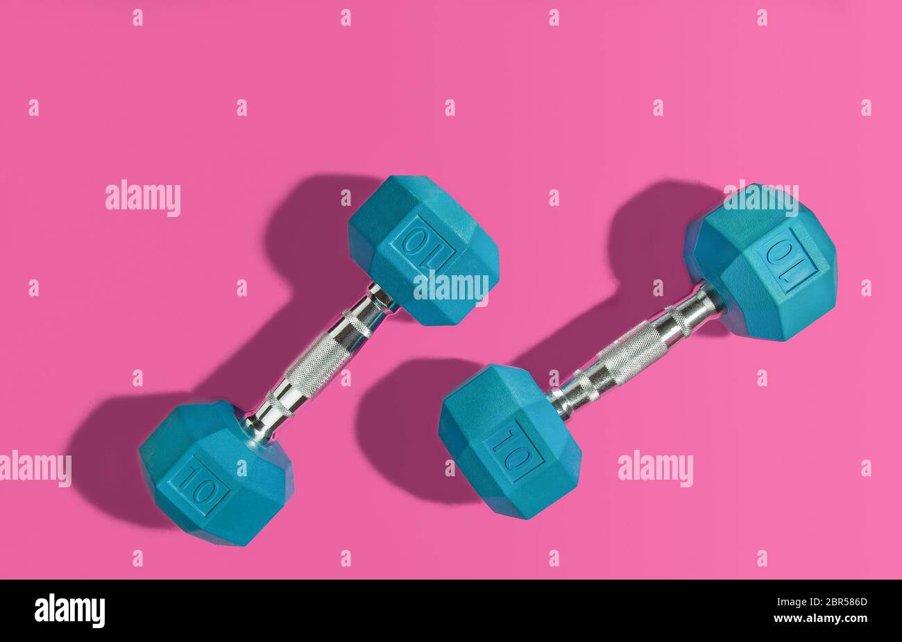 Blue Hand Weights on pink background with shadow Stock Photo - Alamy