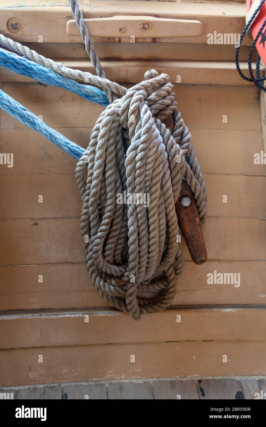 Old ropes coiled around a rusted metal cleat on an old fishing boat ...