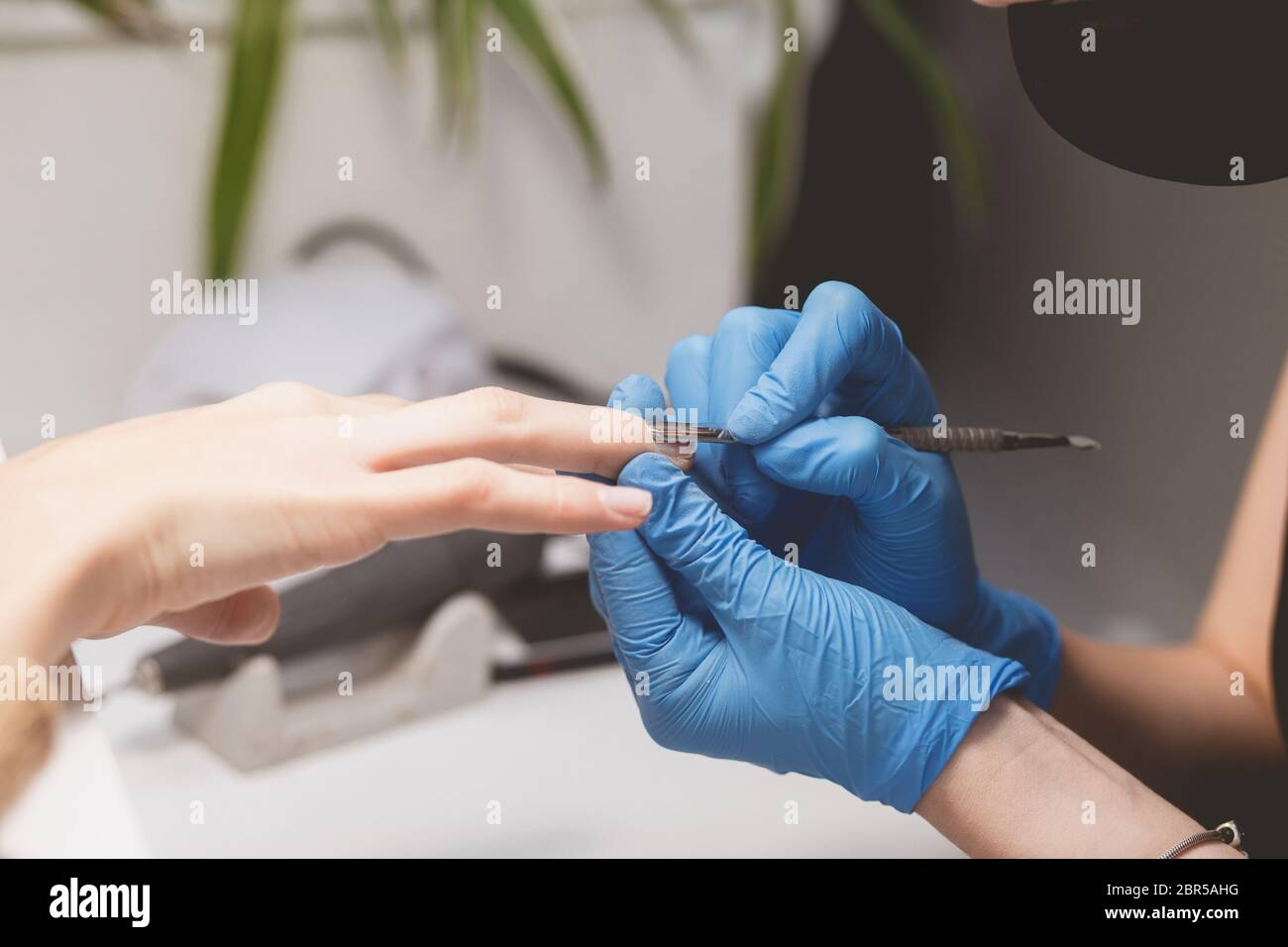 Manicurist cuts cuticle to prepare nails for painting. Manicure ...
