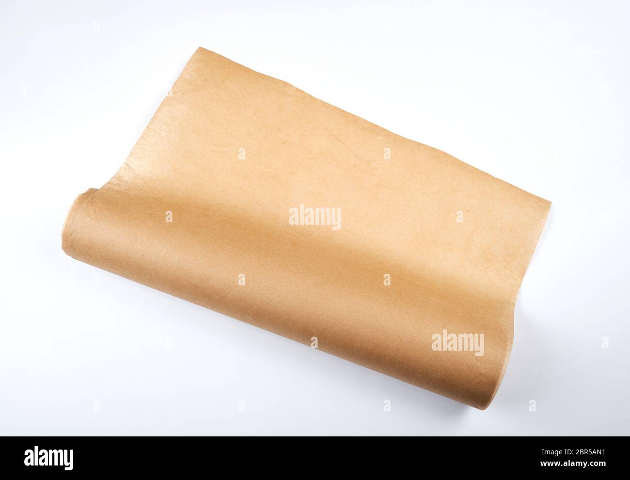 rolled brown parchment paper roll for baking on a white background ...