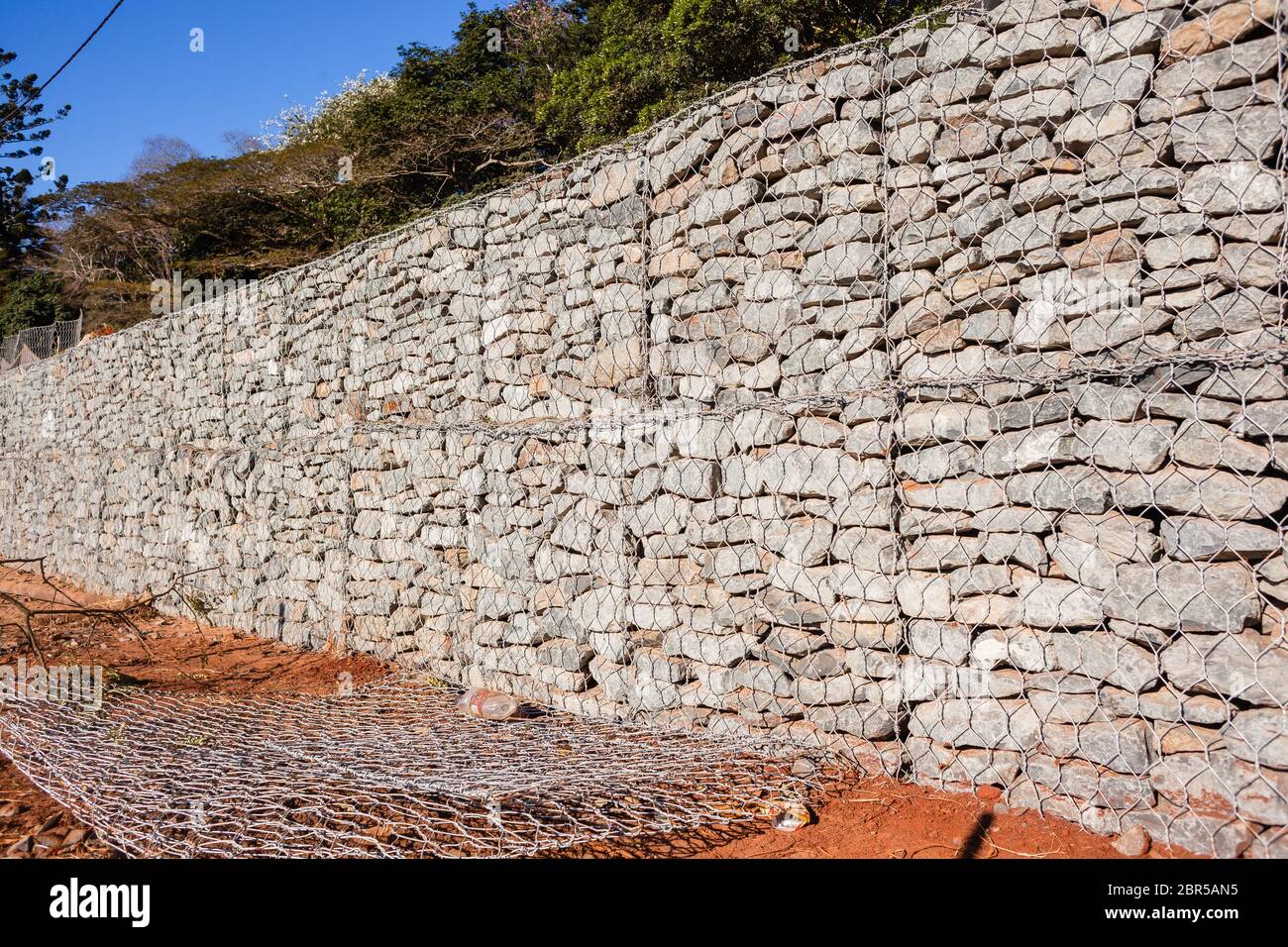 Stone wire cage wall constructed for retaining earth building ...