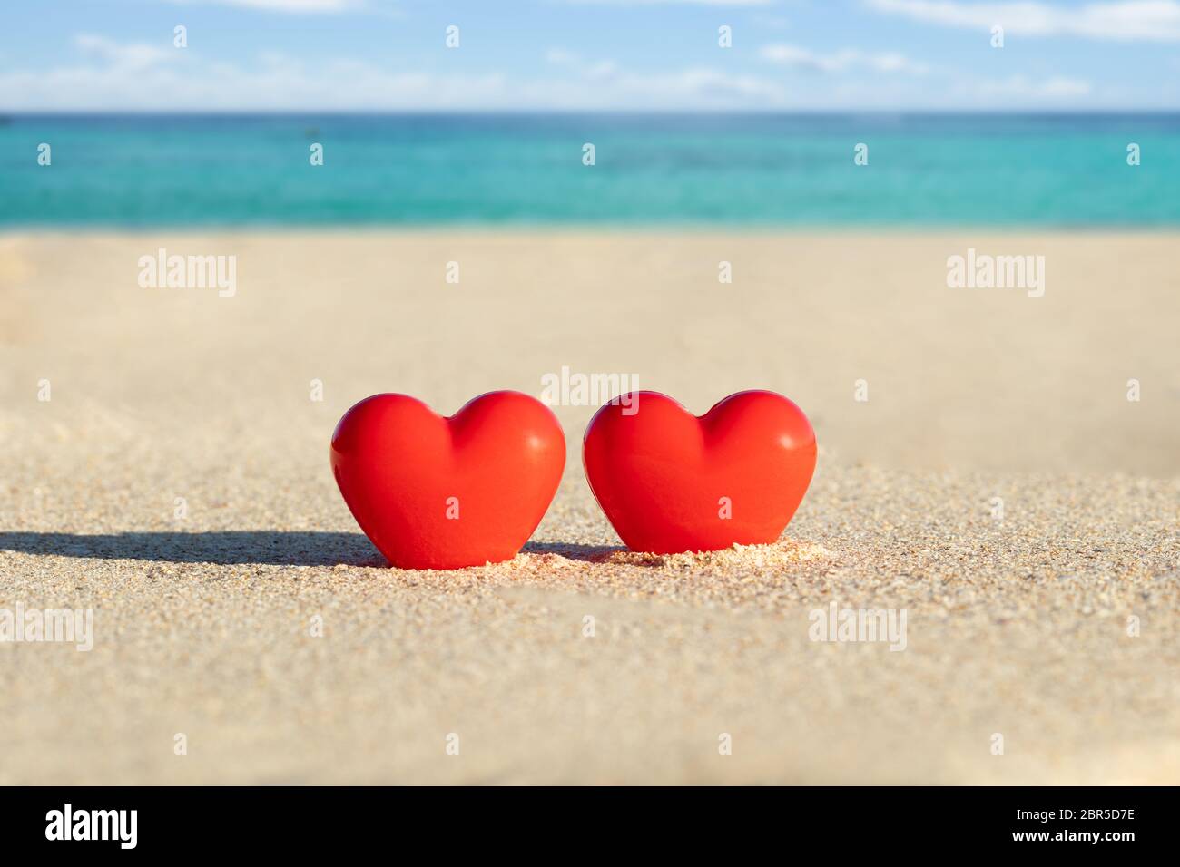 Close-up Of Two Red Heart Shape Dig On Sand At Beach Stock Photo - Alamy