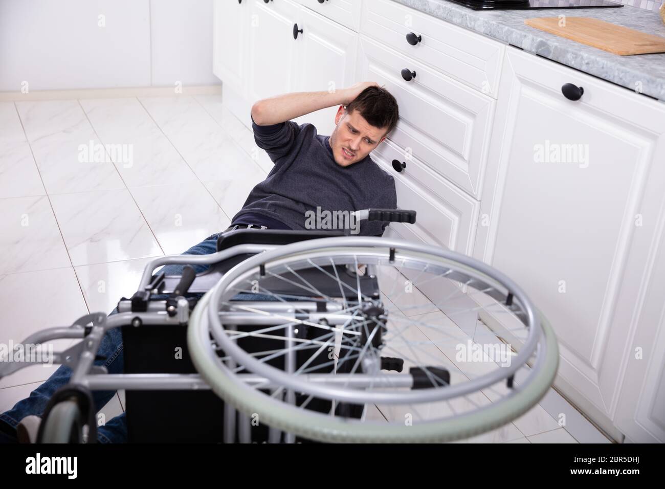 Handicapped Man Fallen Out Of His Wheelchair On Floor In Kitchen Stock ...