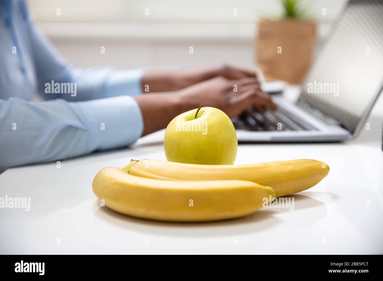 Close-up Of Bananas And Green Apple On Office Desk Stock Photo - Alamy